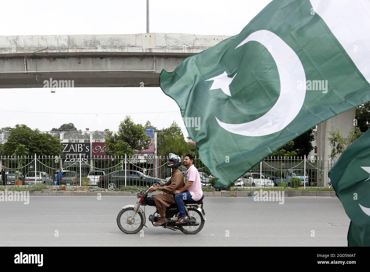 Rawalpindi, Pakistan. 11th Aug, 2021. A motorbike runs past a Pakistani ...