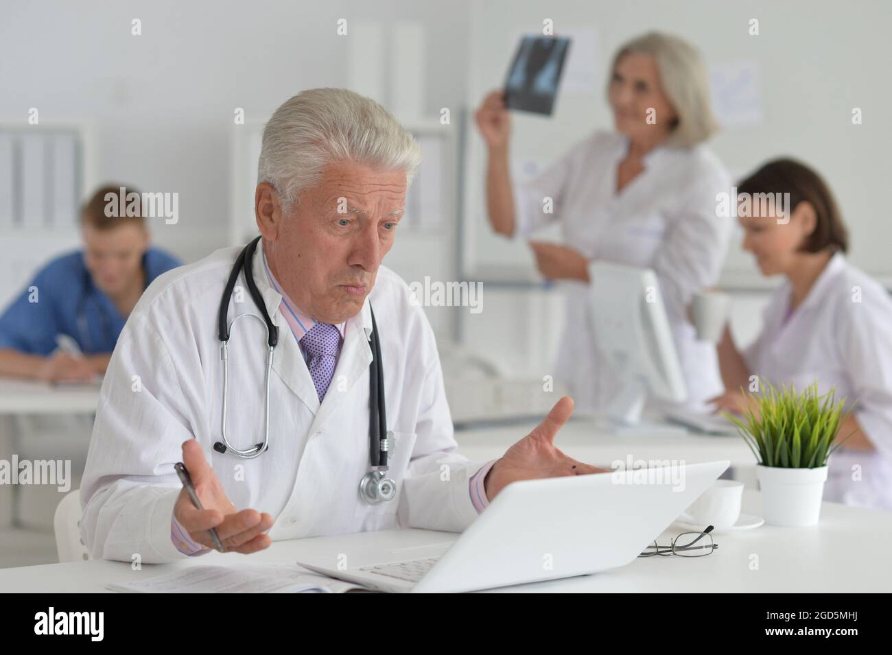 Portrait of a senior doctor working at hospital Stock Photo - Alamy