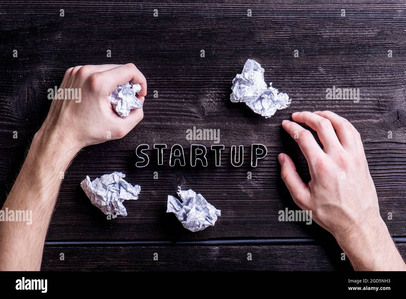 Office desk with start up sign made of cookie cutters and hands of ...