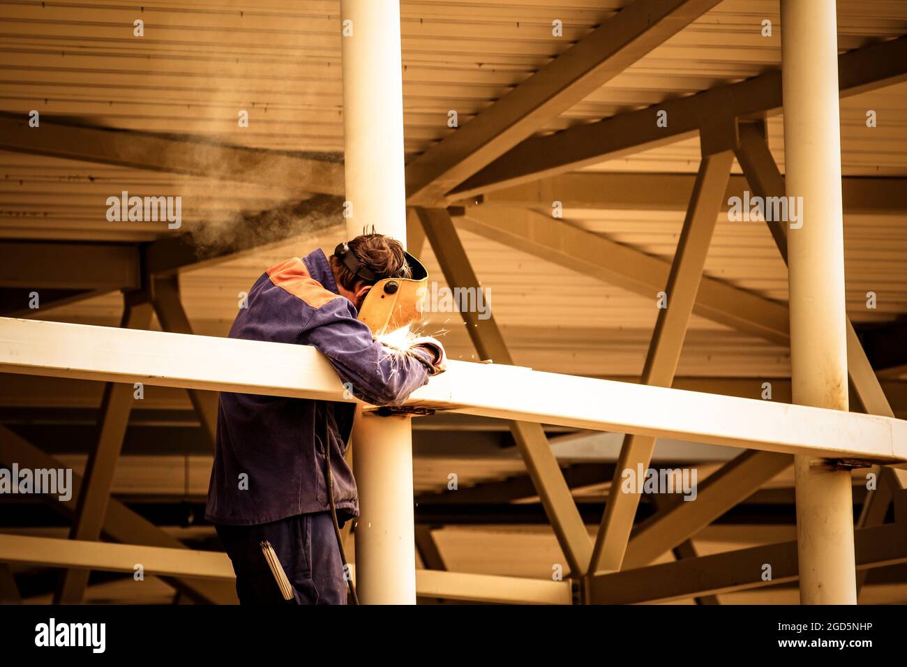 Man welder in welding mask, building uniform and protective gloves ...