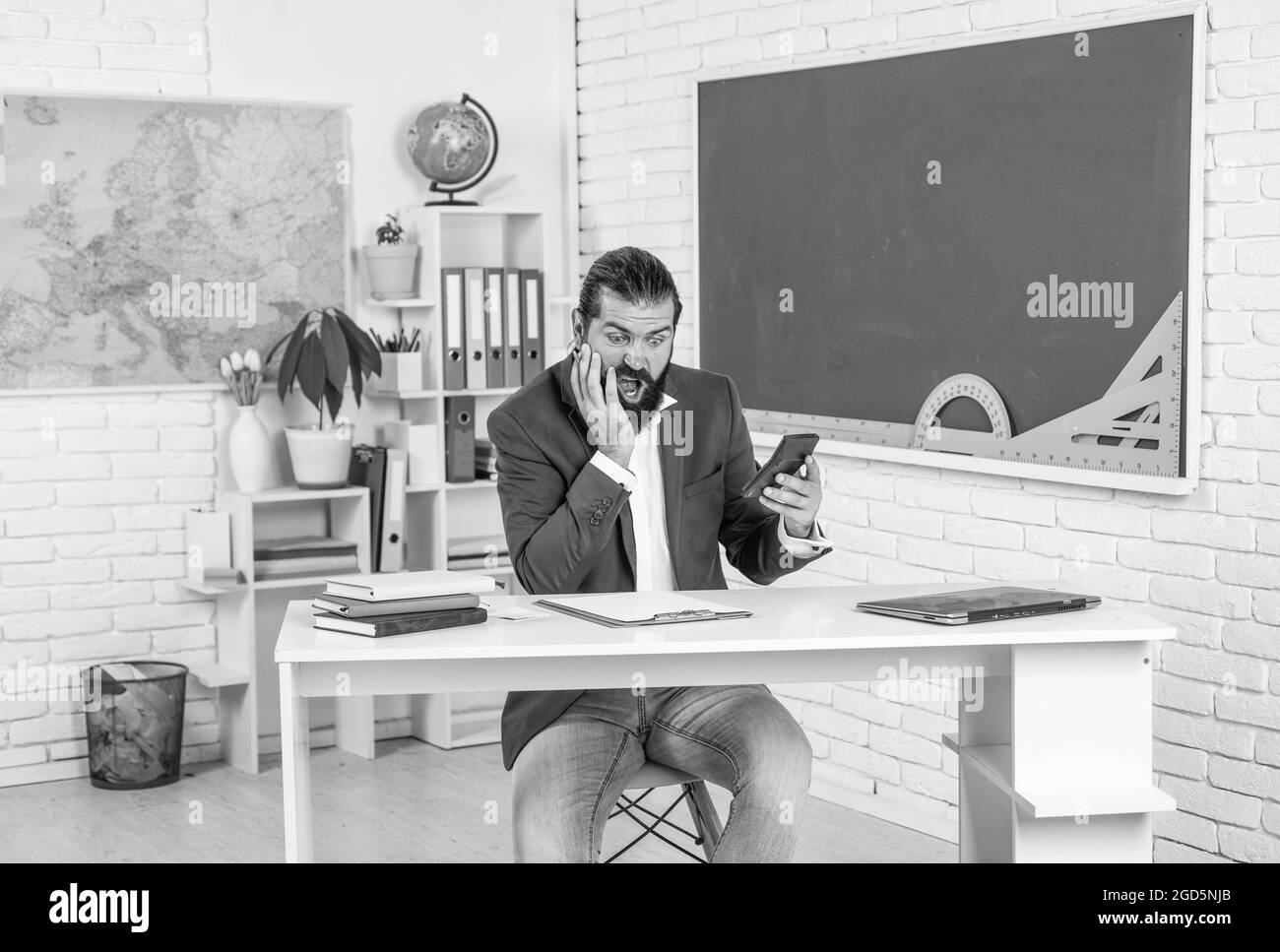 confused man with beard calculating on calculator in school math lesson ...