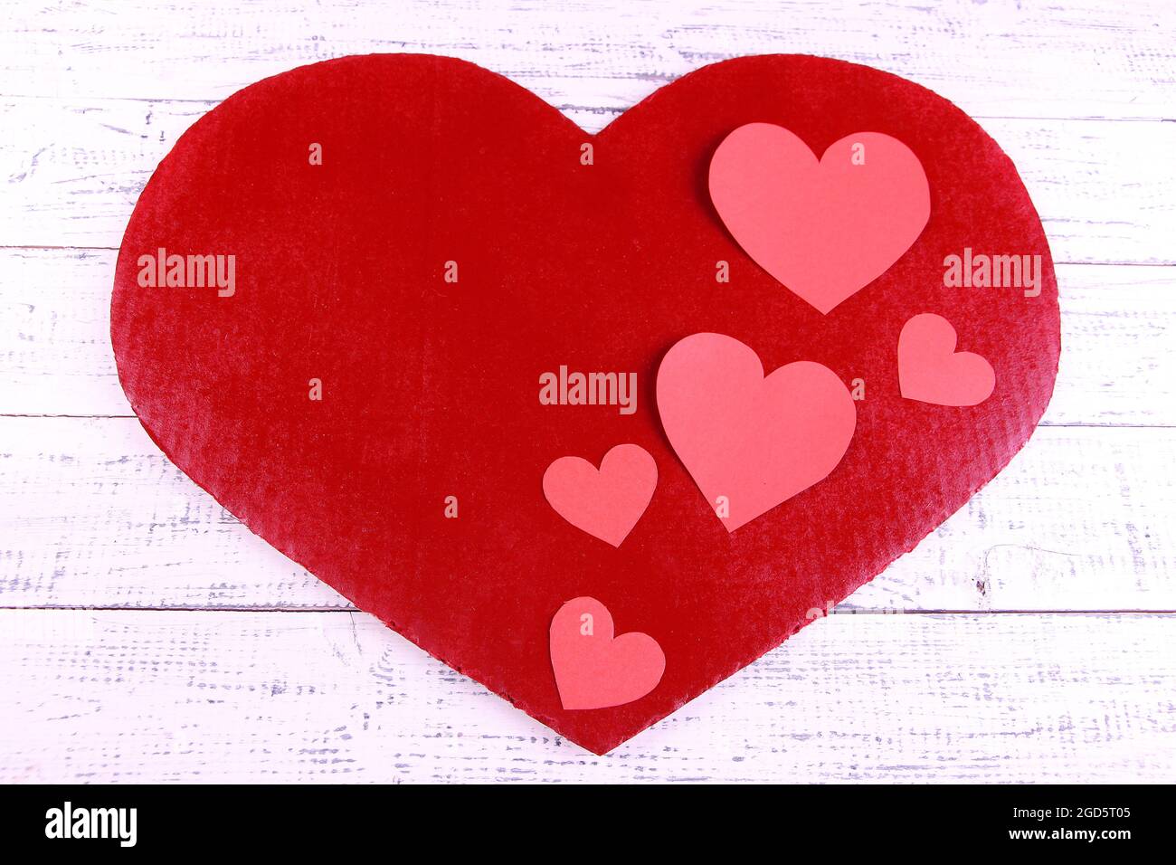 Big red heart with small hears on wooden background Stock Photo - Alamy