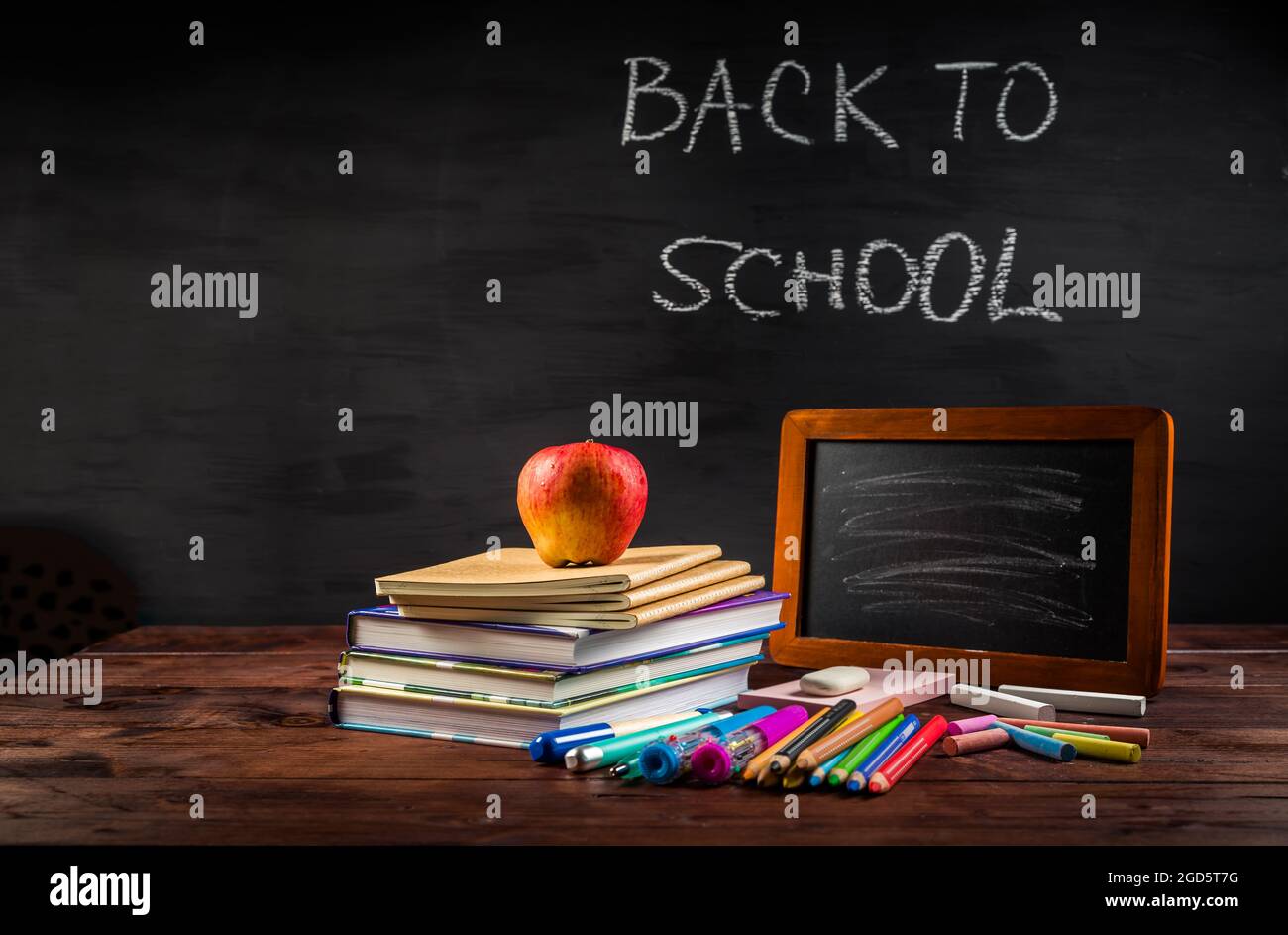 Pile of book and exercise books with shool applies and apple snack with ...