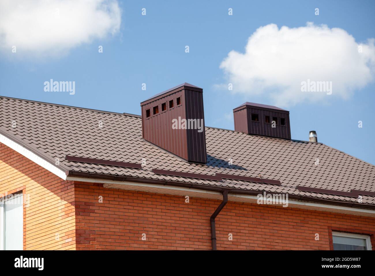 Red metal roof tile and smokestack. Modern chimney on brown roof Stock ...