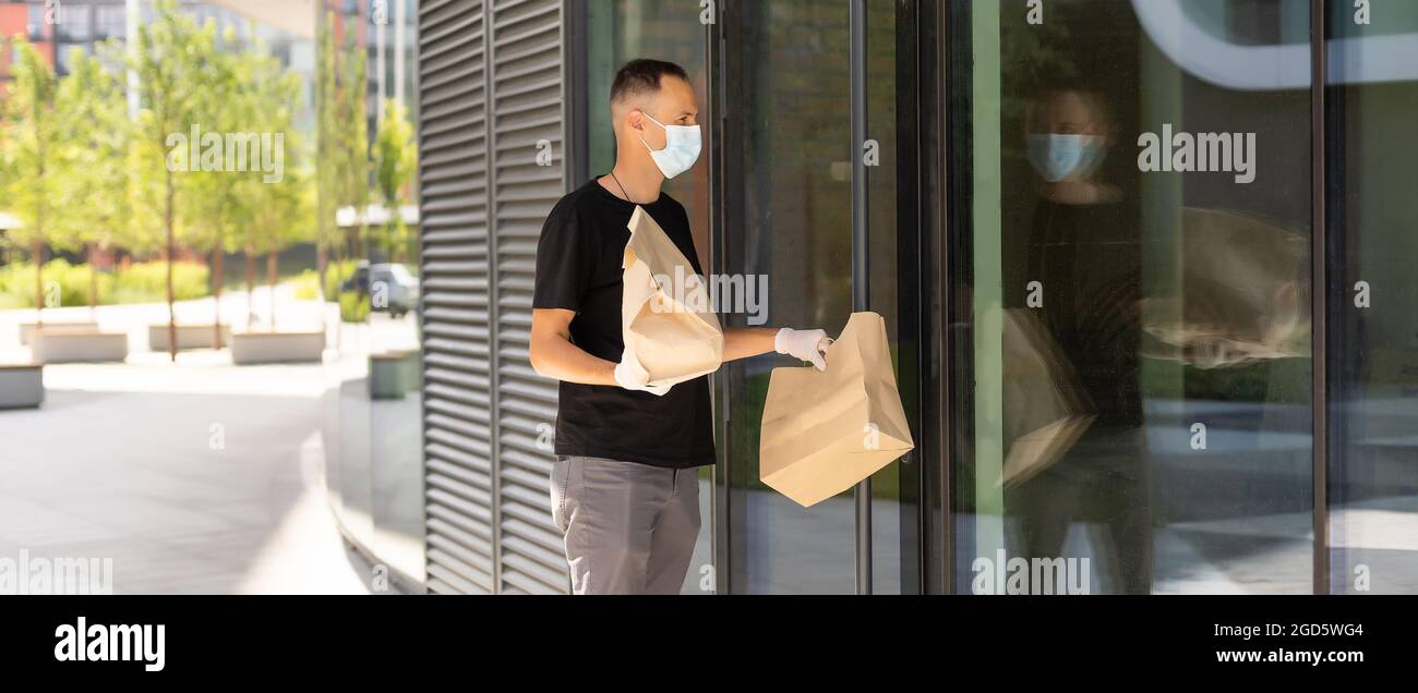 delivery guy in protective mask near the customer house, outdoors Stock ...