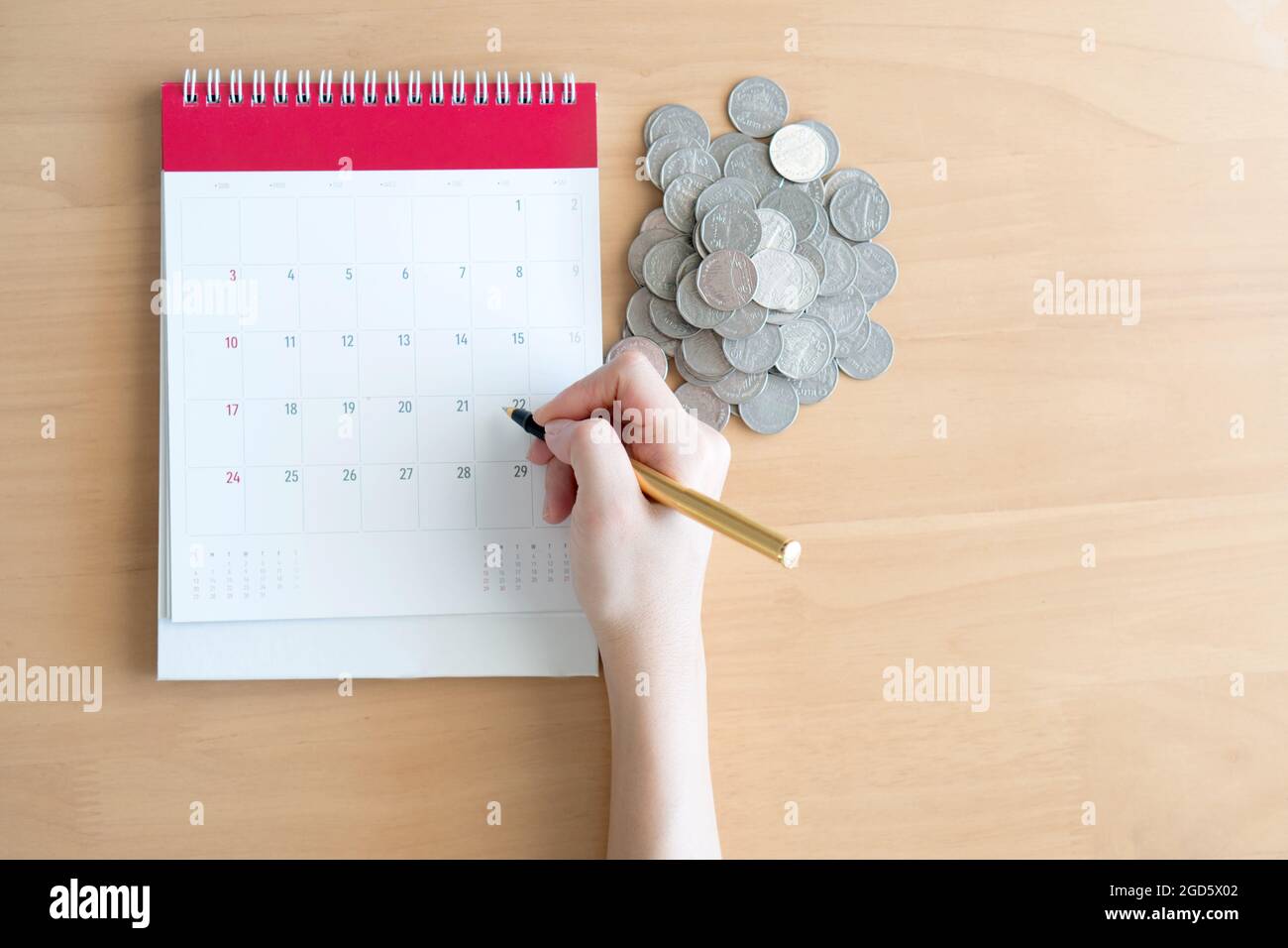 Hand writing in calendar plan and coins concept Stock Photo - Alamy