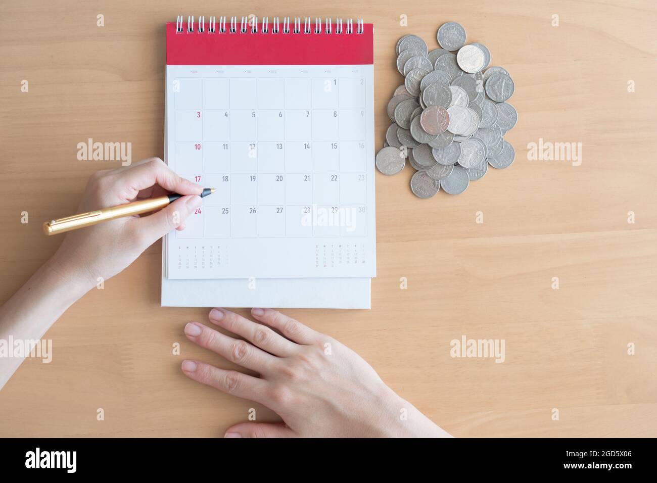 Hand writing in calendar plan and coins concept Stock Photo - Alamy
