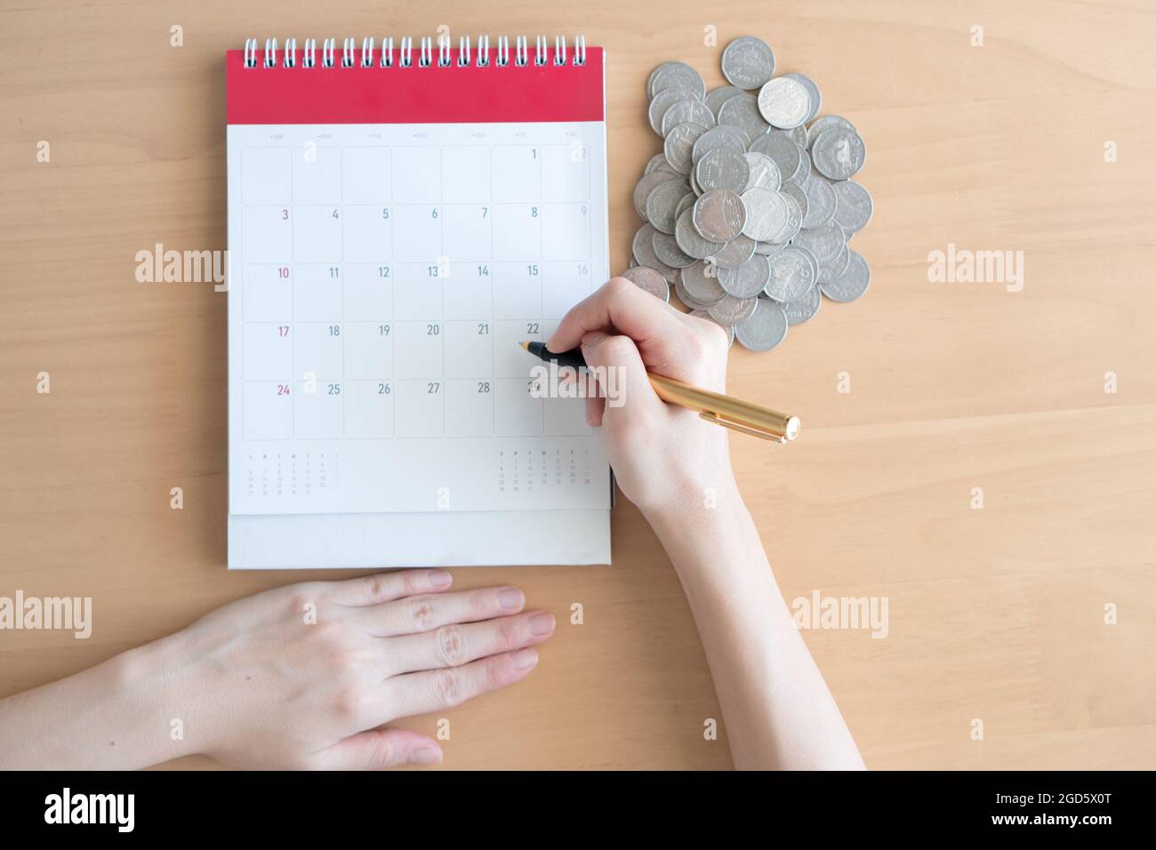 Hand writing in calendar plan and coins concept Stock Photo - Alamy