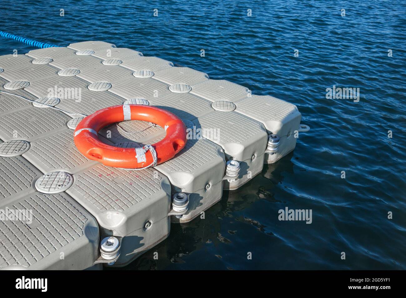 Red life buoy lays on an empty floating pontoon. Swimming area rescue ...