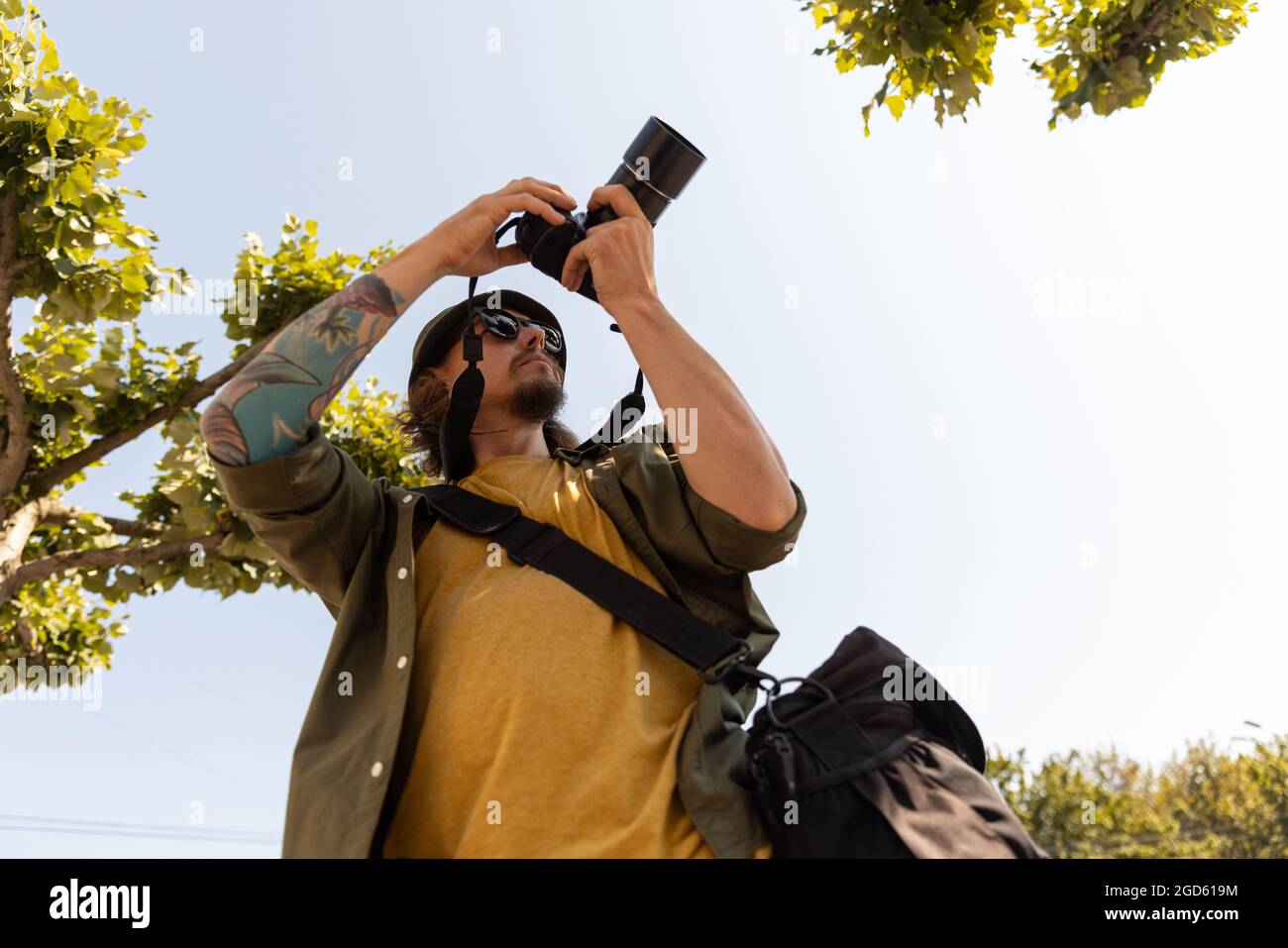 Portrait of young man, photographer, cameraman with professional camera ...