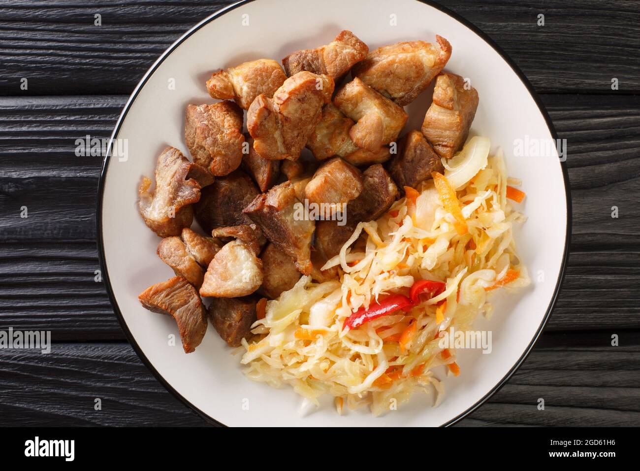 Haitian Fried Pork Griot with pickled vegetable salad close-up in a ...