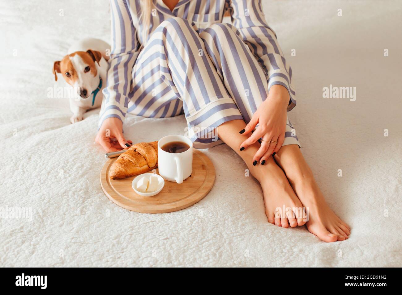 morning breakfast in bed croissant and coffee. next to her is a woman ...