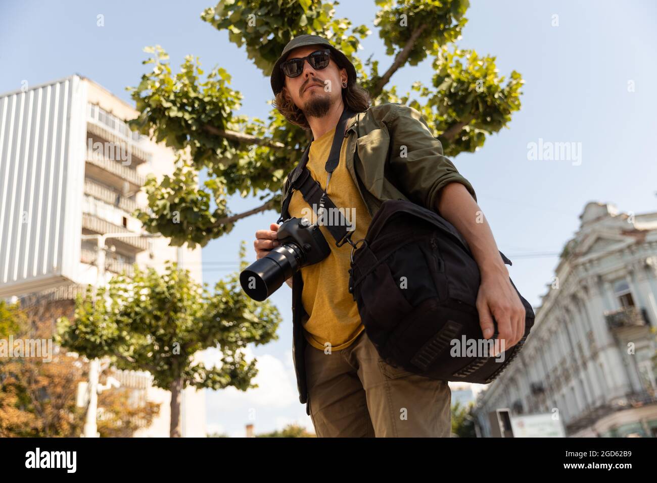 Portrait of young man, photographer, cameraman with professional camera ...