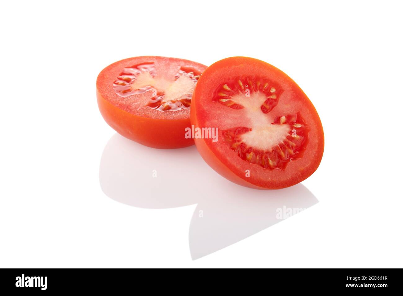 Sliced tomato. Two half tomatoes facing right on a white background ...