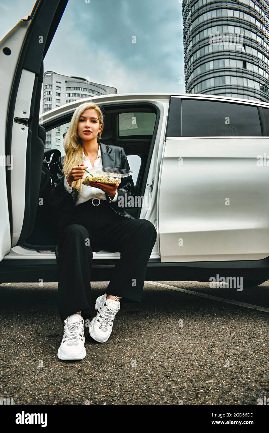 business lunch in the car. girl eating fast food on the road Stock ...