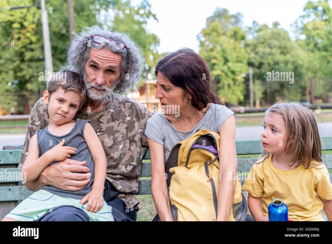 happy family is having fun sitting on a bench in an outdoor park Stock ...
