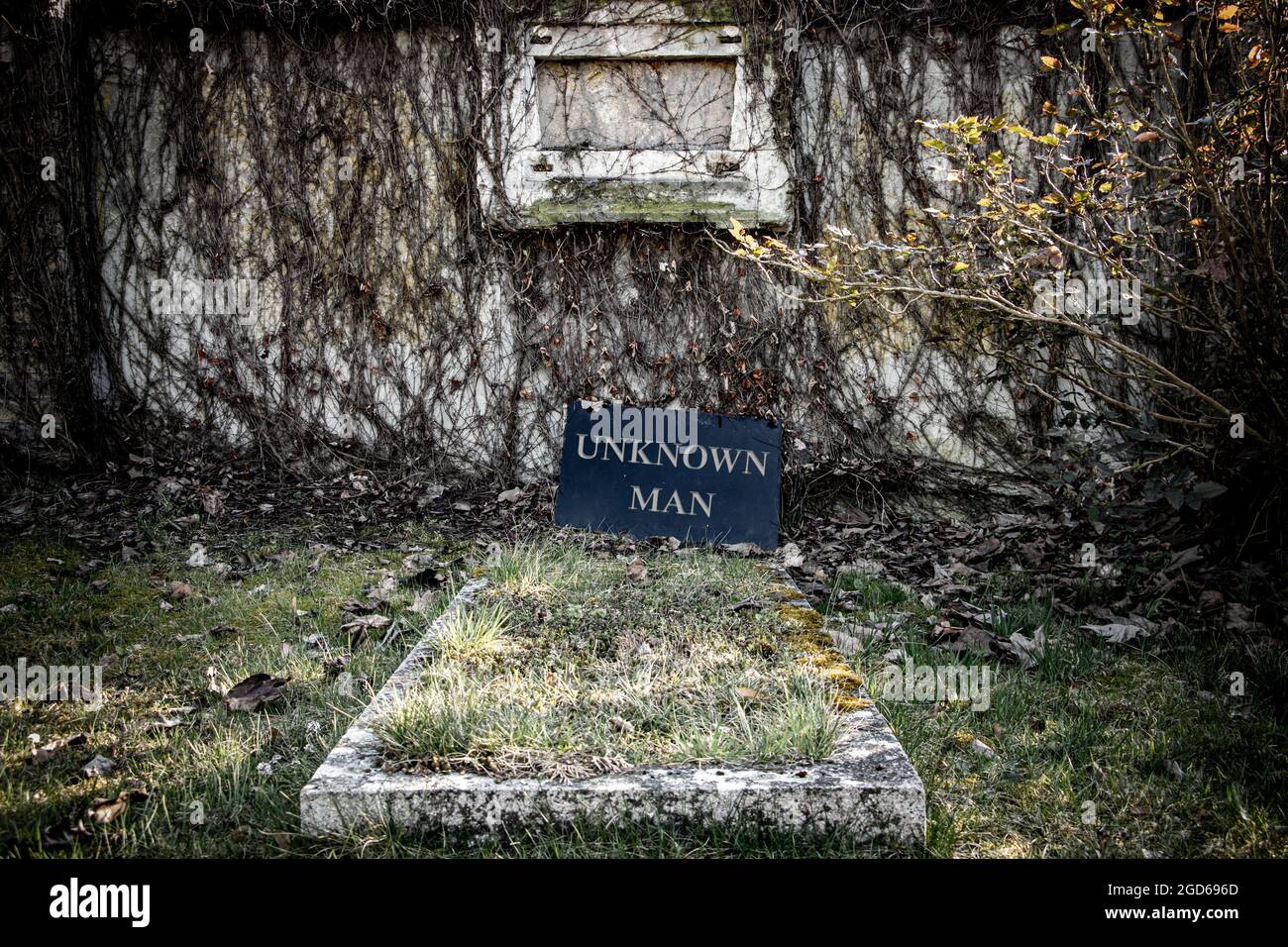 The unkempt grave with a fallen plaque with the inscription Unknown man ...