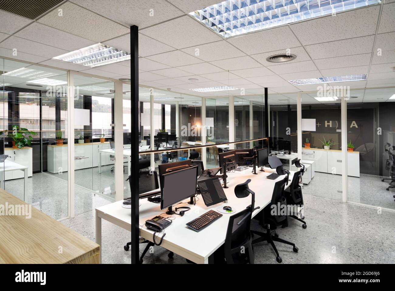 Open space office with computer monitors on white desks Stock Photo - Alamy