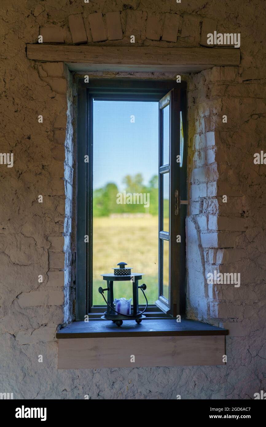 ancient brick building window with a view of the summer old meadow and ...