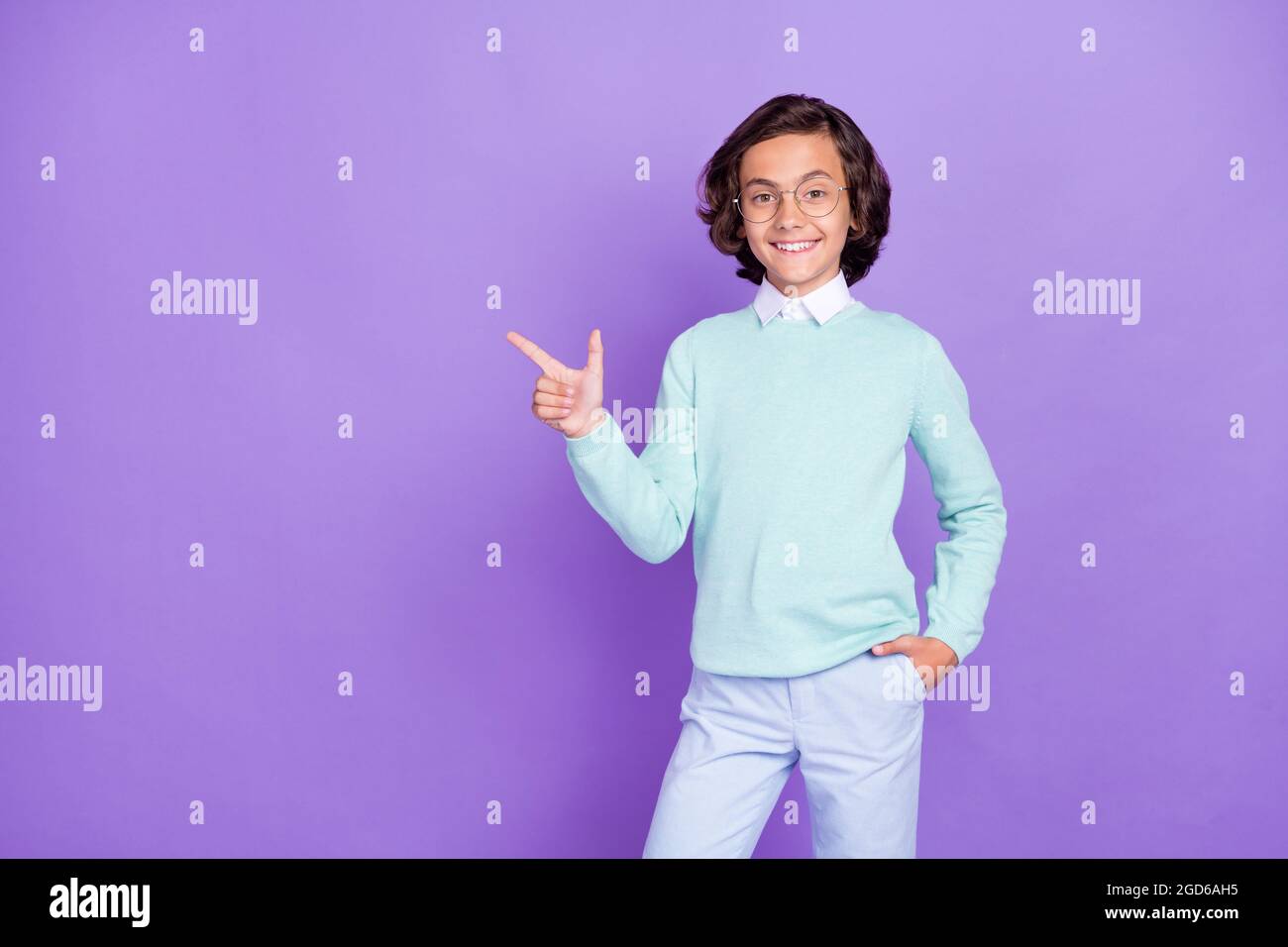 Photo of small funny brunet boy point empty space wear blue sweater ...