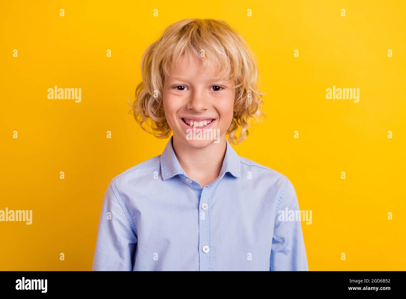 Photo of funky little boy wear blue shirt isolated on yellow color ...