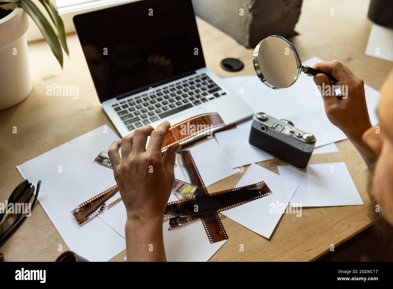 Close-up hands and objects for photographer work. Laptop, loupe and ...
