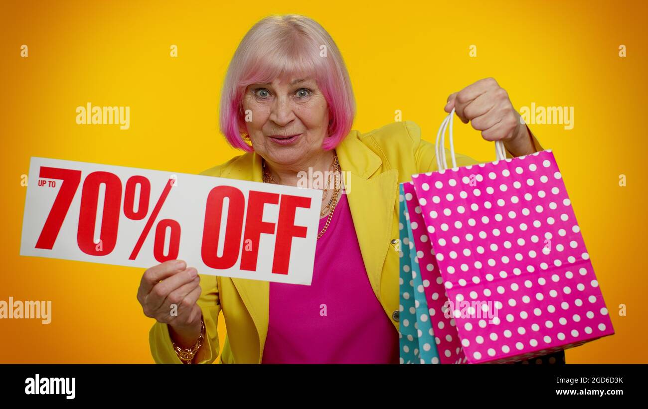 Senior granny woman showing shopping bags and Up To 70 Percent Off ...