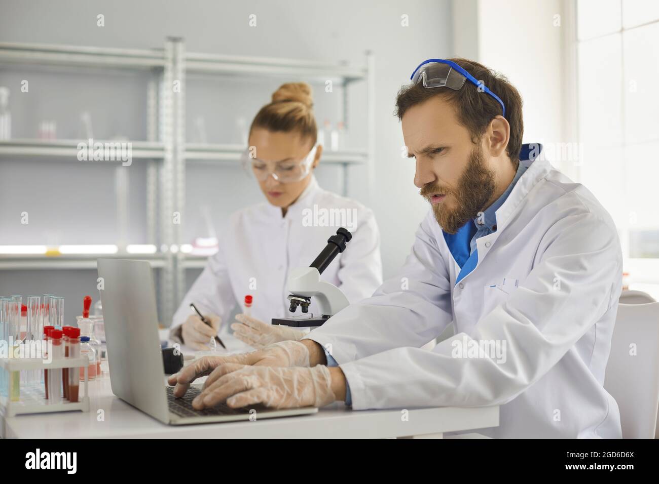 Concentrated scientist typing laptop keyboard working on research ...