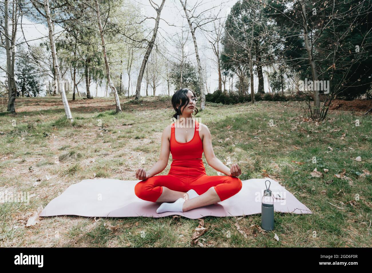 Middle Eastern female practicing yoga on the mat in the middle of a ...