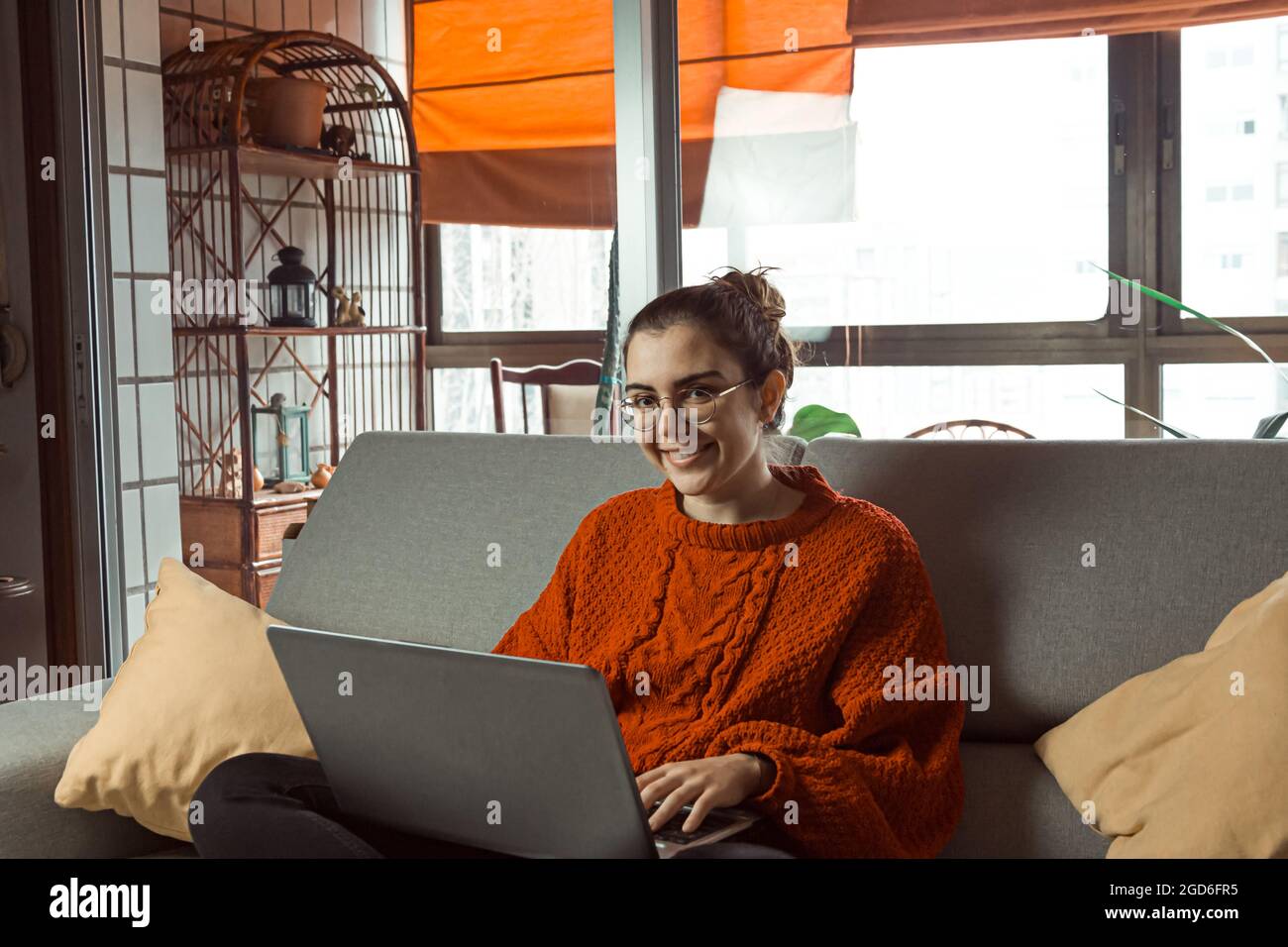 Caucasian woman working through her laptop while seated on the couch ...