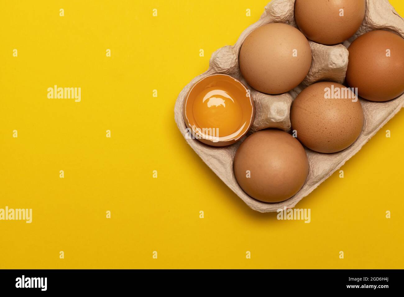 Fresh Easter brown chicken eggs in eco basket and one egg on yellow ...