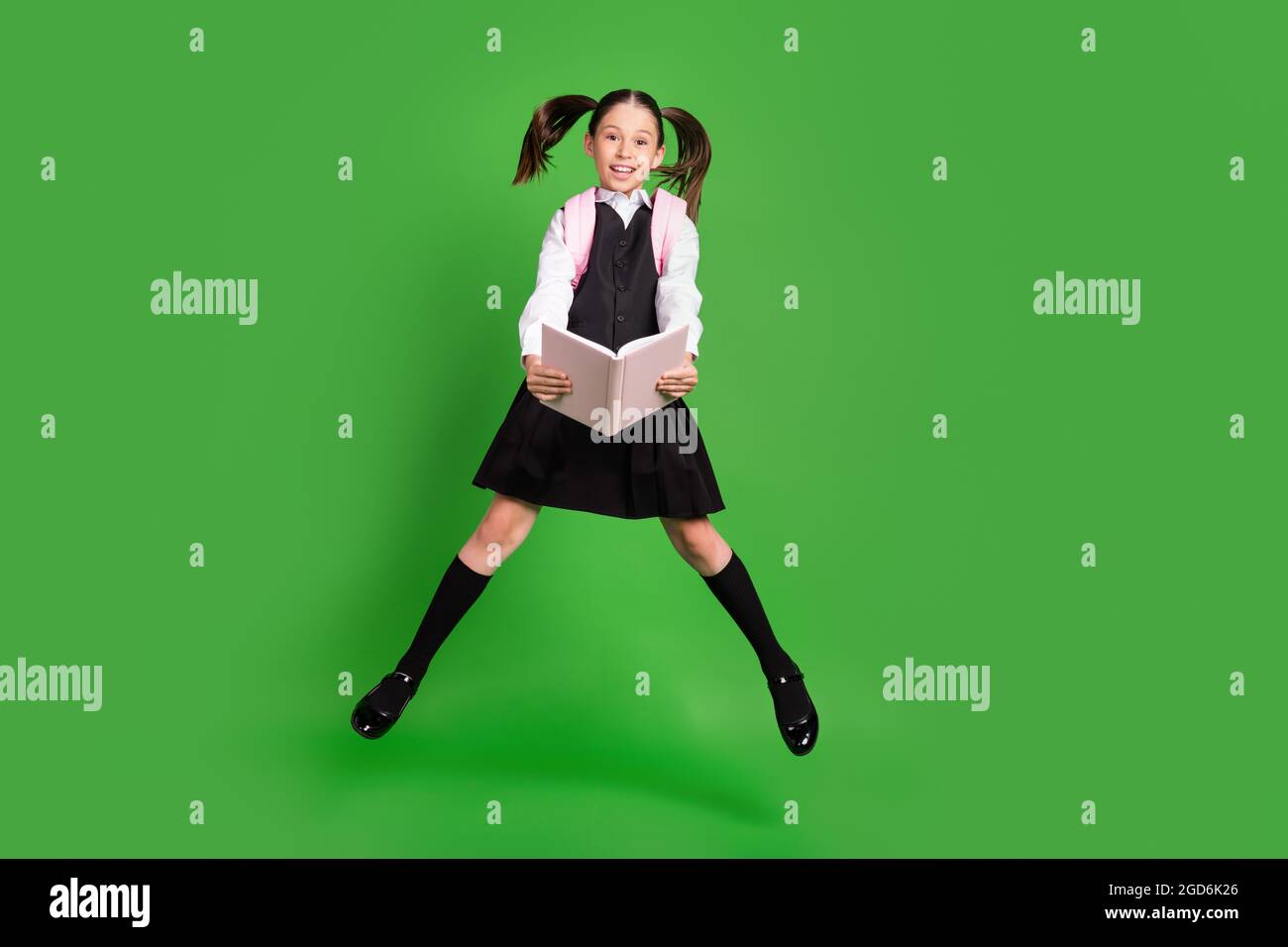 Full length body size view of pretty cheerful girl jumping reading book ...