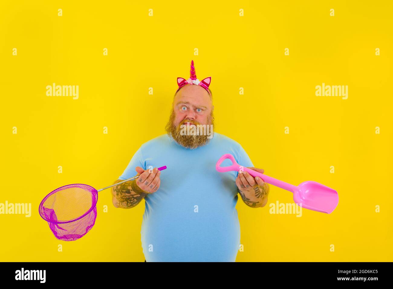 fat man with headband play with sea net and paddle Stock Photo - Alamy