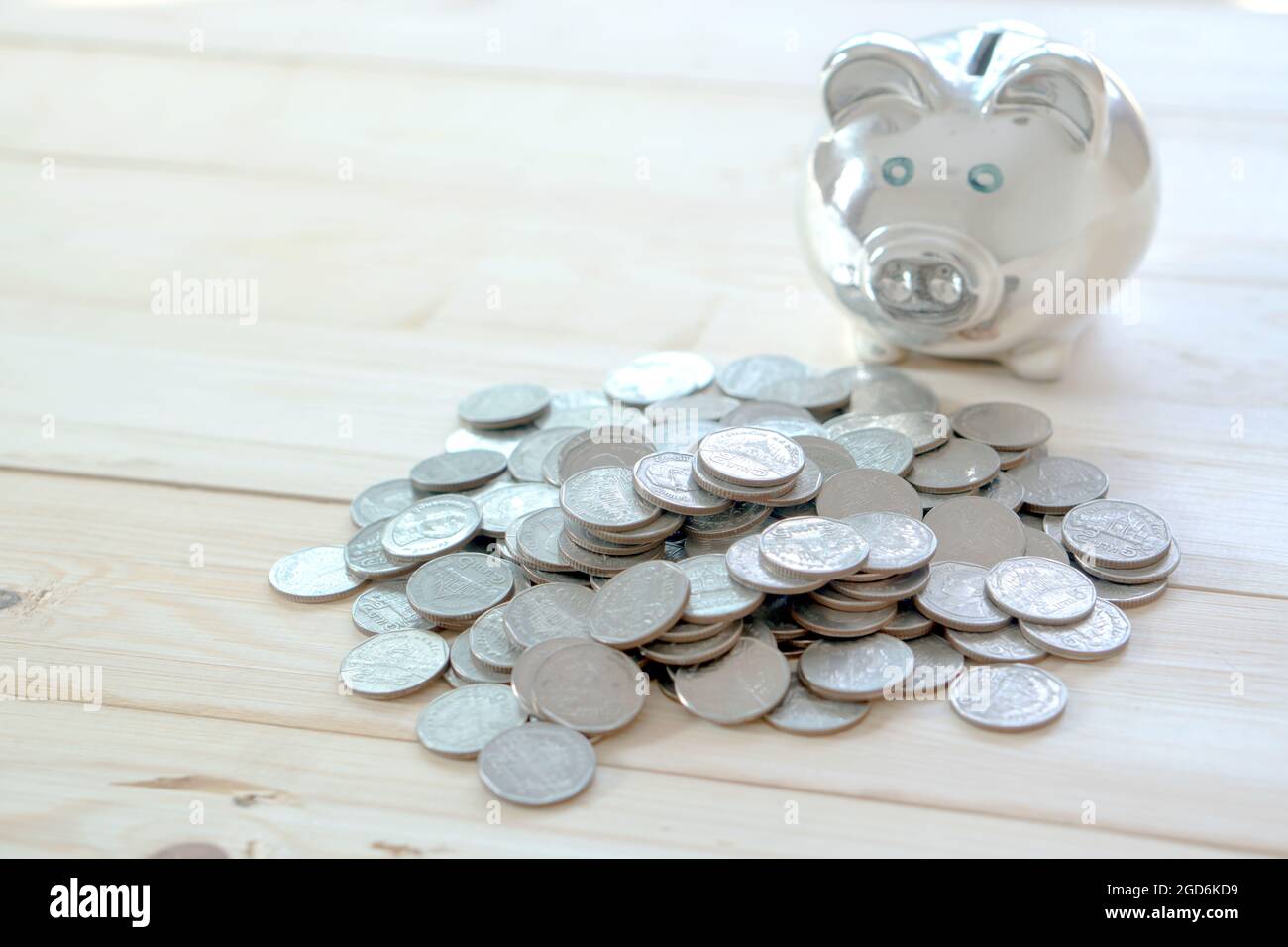 Coin is getting into piggy bank on table. Concept of saving money Stock ...