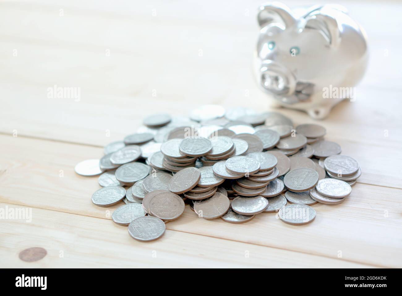 Coin is getting into piggy bank on table. Concept of saving money Stock ...