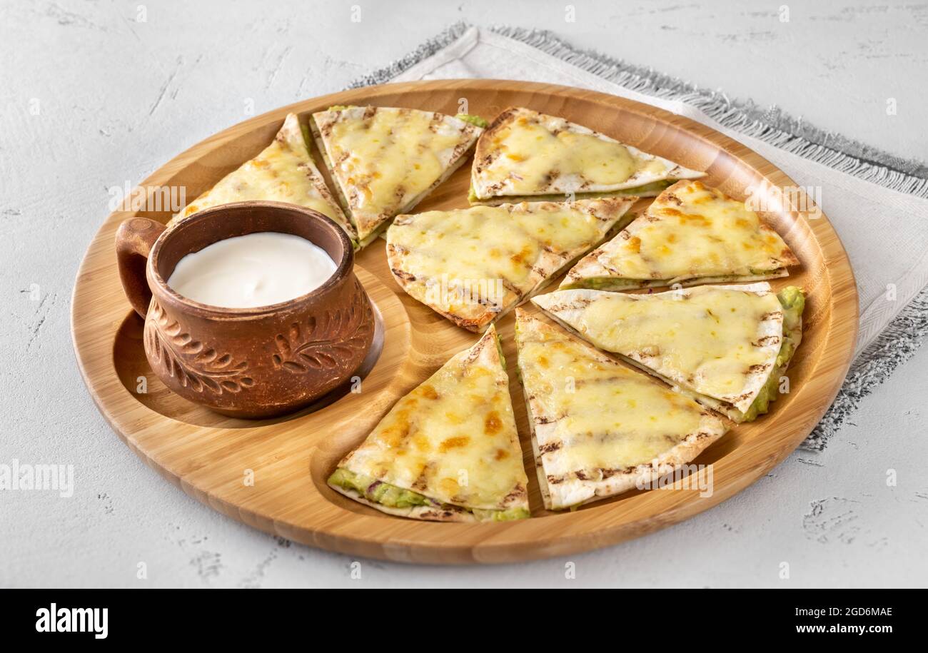Quesados - Mexican appetizer garnished with sour cream Stock Photo - Alamy