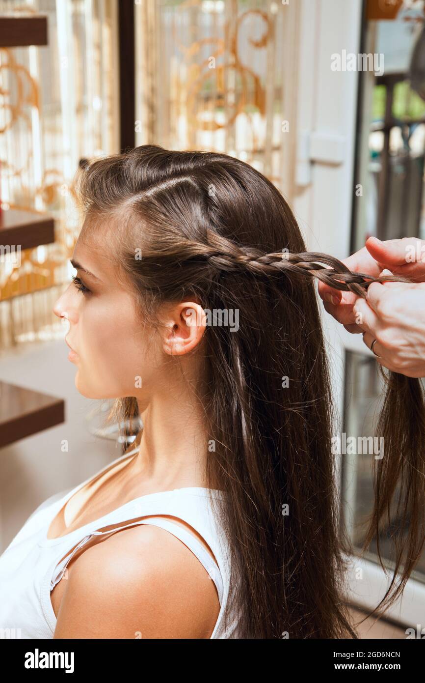 young woman in hair salon making braid of hair Stock Photo - Alamy