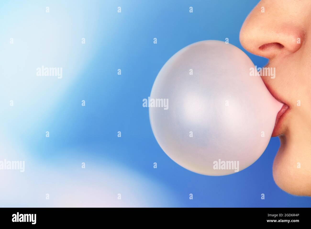 Person doing bubble with chewing gum on bright background Stock Photo ...