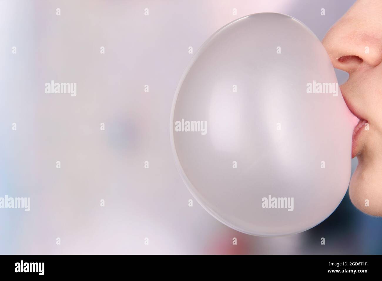 Person doing bubble with chewing gum on bright background Stock Photo ...