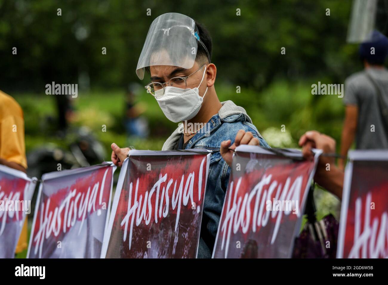 A protester wears a protective mask with a sign ahead of President ...