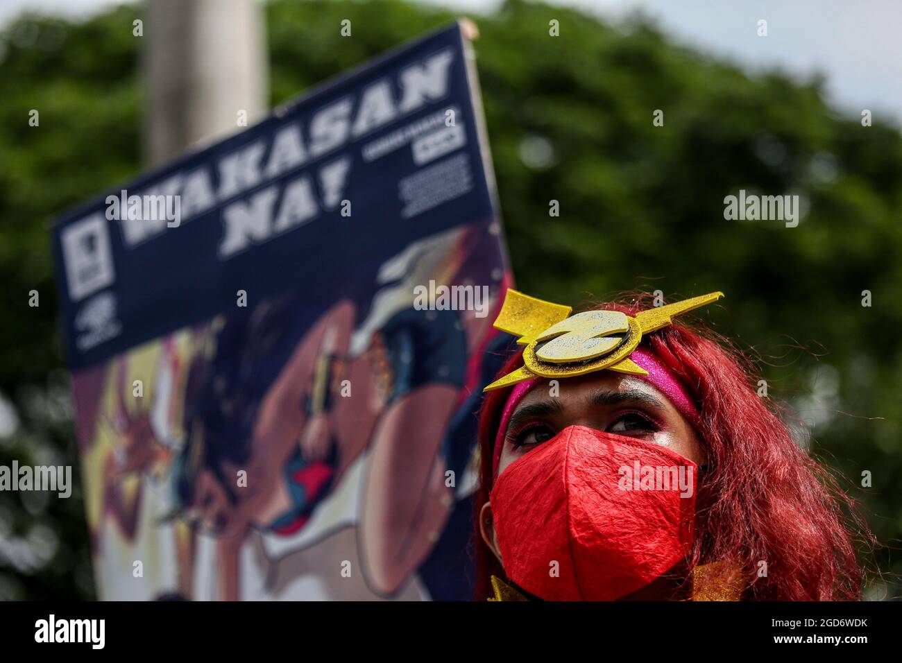 A protester wears a protective mask with a sign ahead of President ...