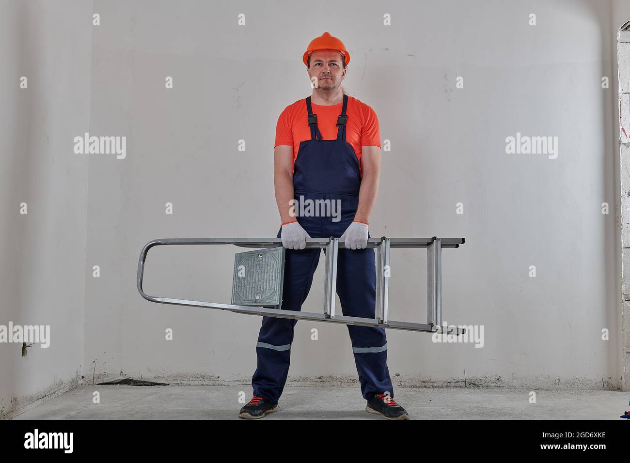 a very strong man holding a ladder in front of him Stock Photo - Alamy