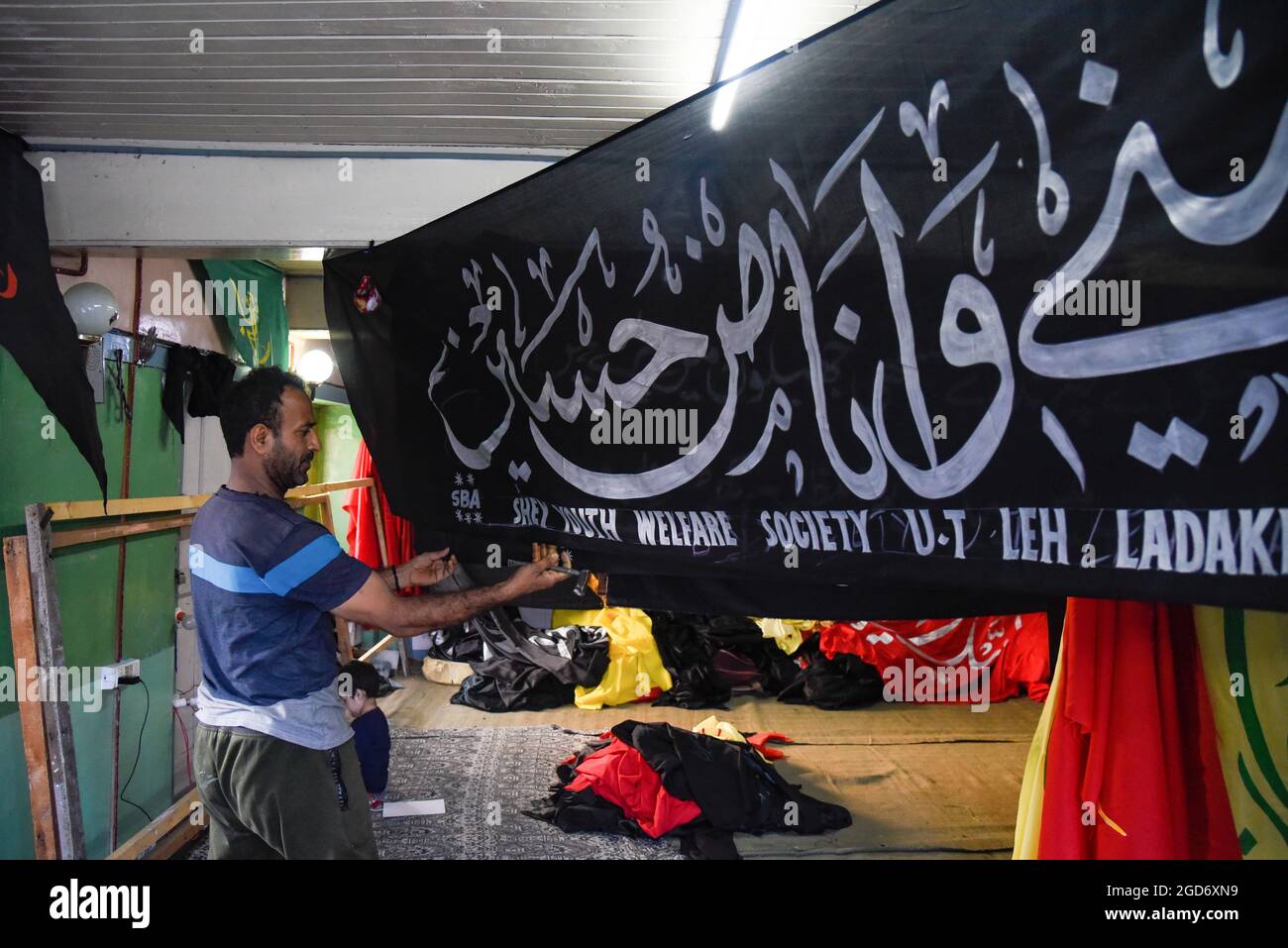 An artist seen designing banners ahead of Ashura. Muharram is the first ...