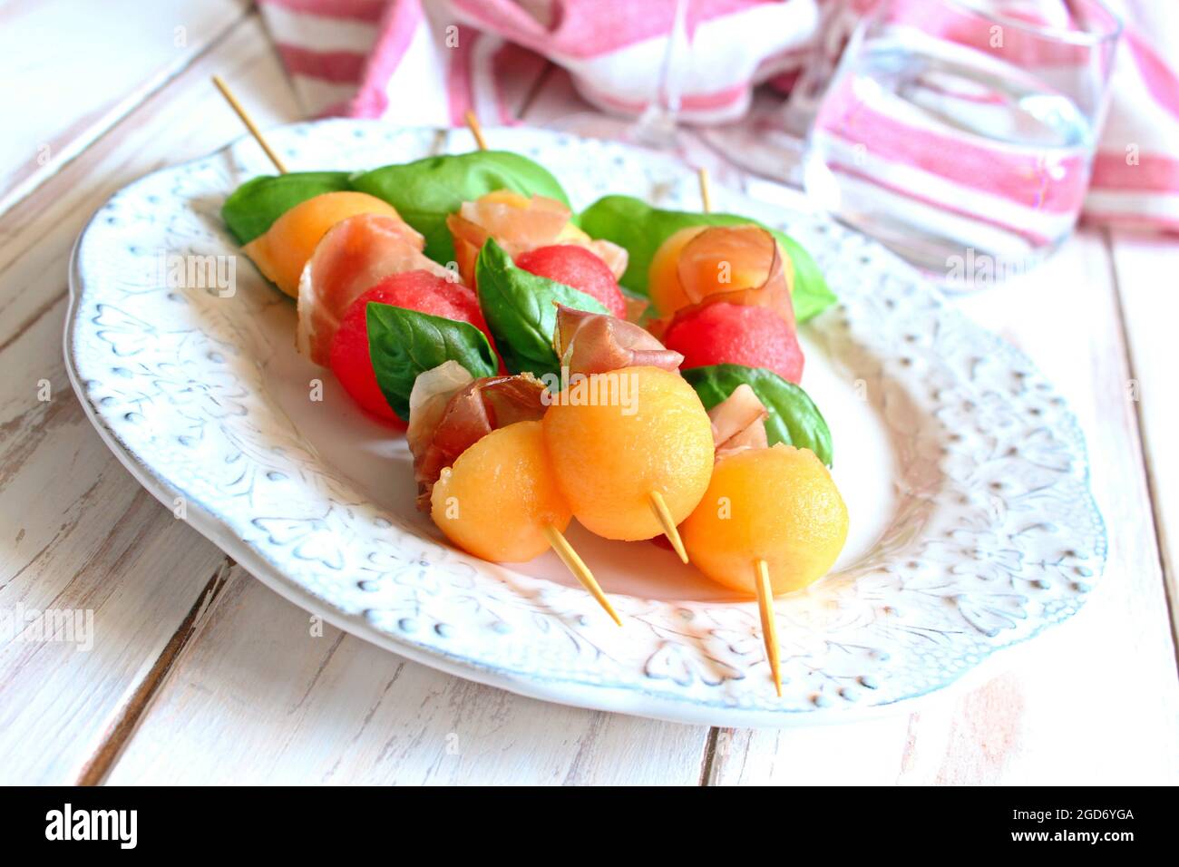 Healthy snack melon, watermelon, raw ham and basil on white background ...