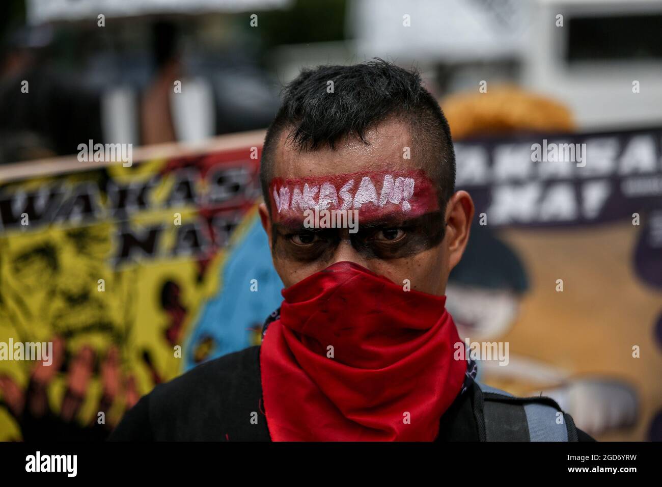 A protester wears a protective mask with a sign ahead of President ...