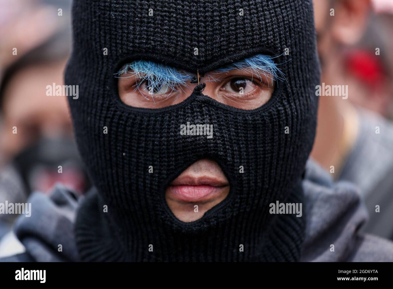 A protester wears a protective mask with a sign ahead of President ...
