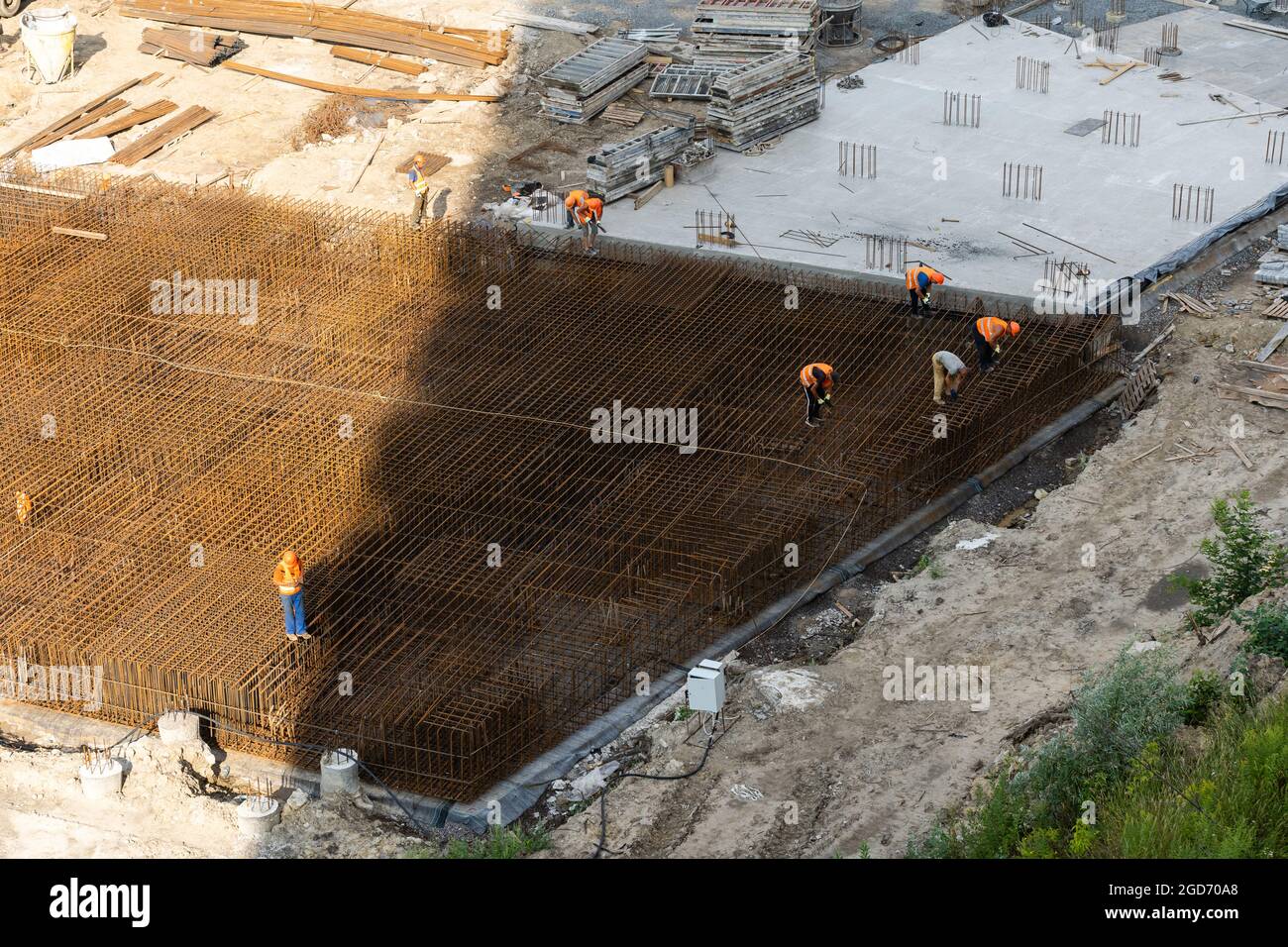 concreting work: construction site worker during concrete pouring into ...