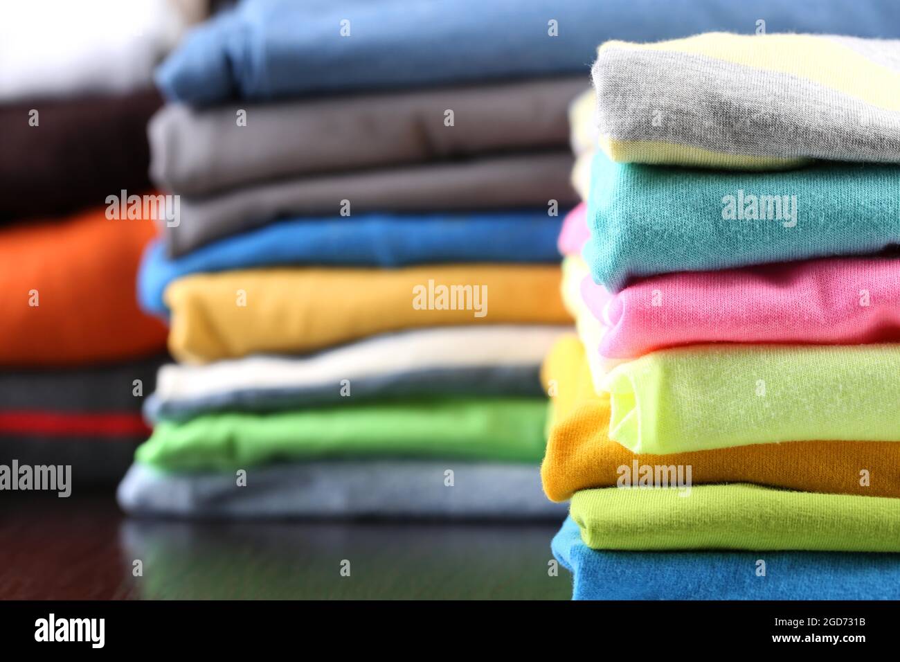 Stack of colorful clothes, on dark background Stock Photo - Alamy