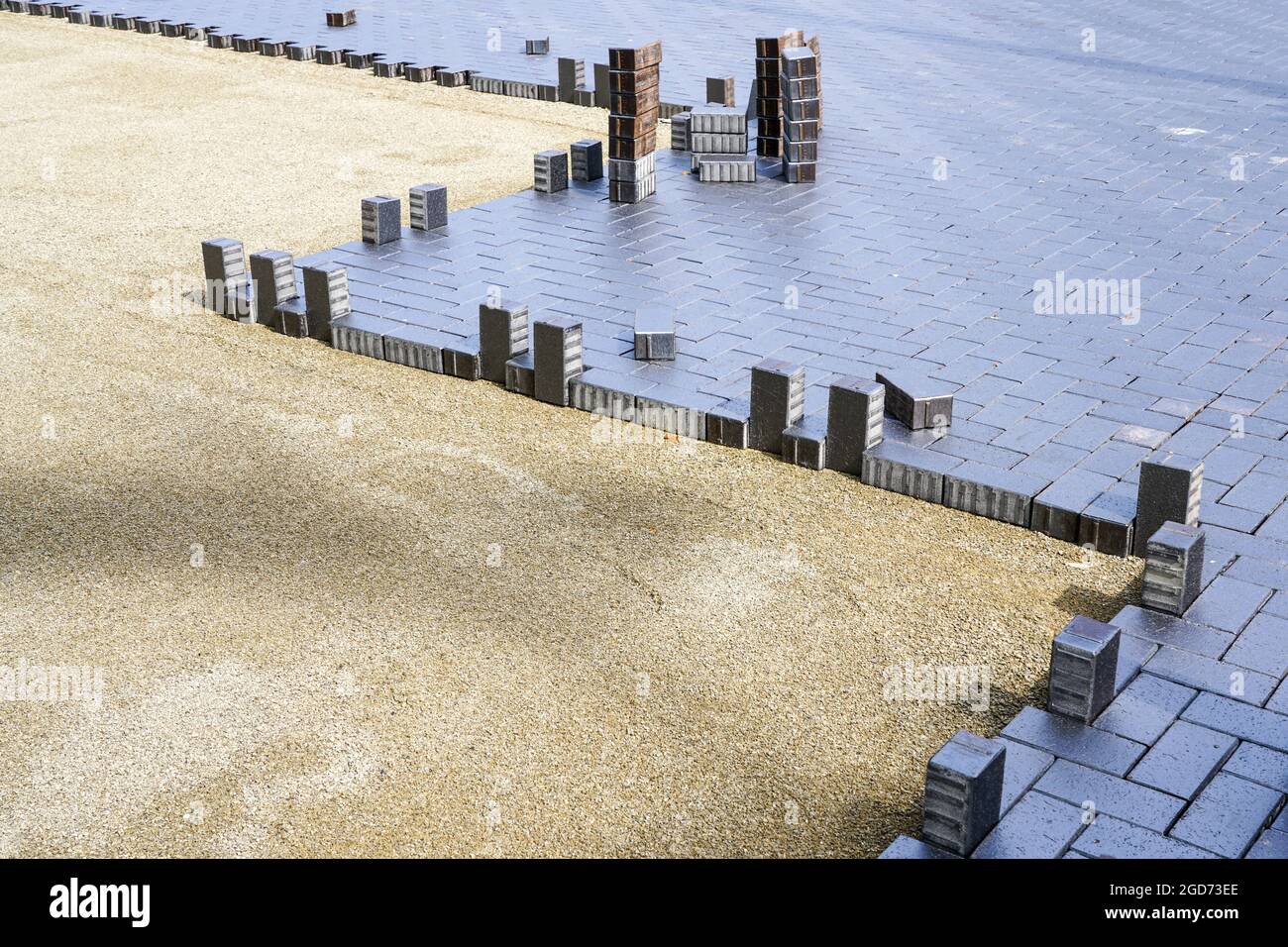 laying of modern beautiful design cobblestones on a flat prepared ...