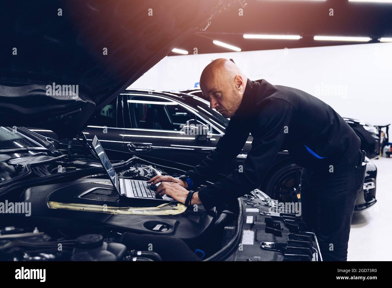 Car service worker diagnosis engine and car systems Stock Photo - Alamy